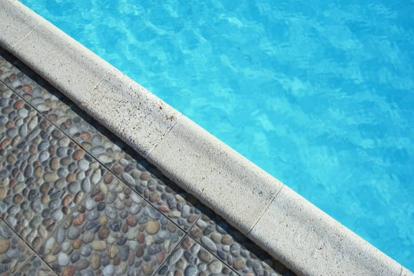 Pebble Stone Pool Deck vs. Stamped Concrete: Which Wins?